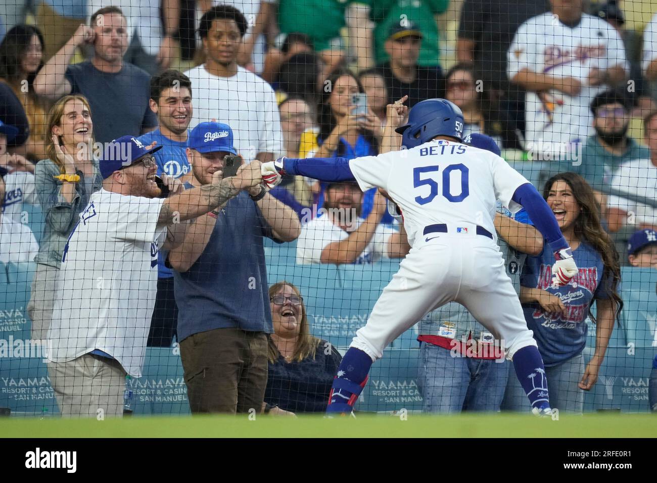 Los Angeles Dodgers' Mookie Betts fist bumps a fan after hitting a home ...