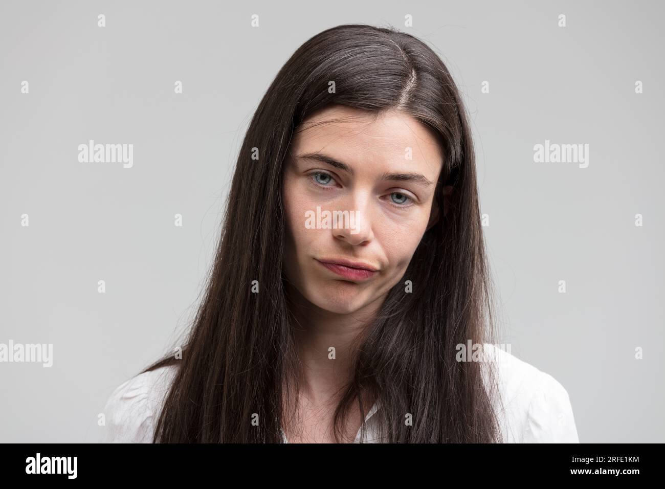 Central frontal portrait of a woman showing disgust, annoyance ...