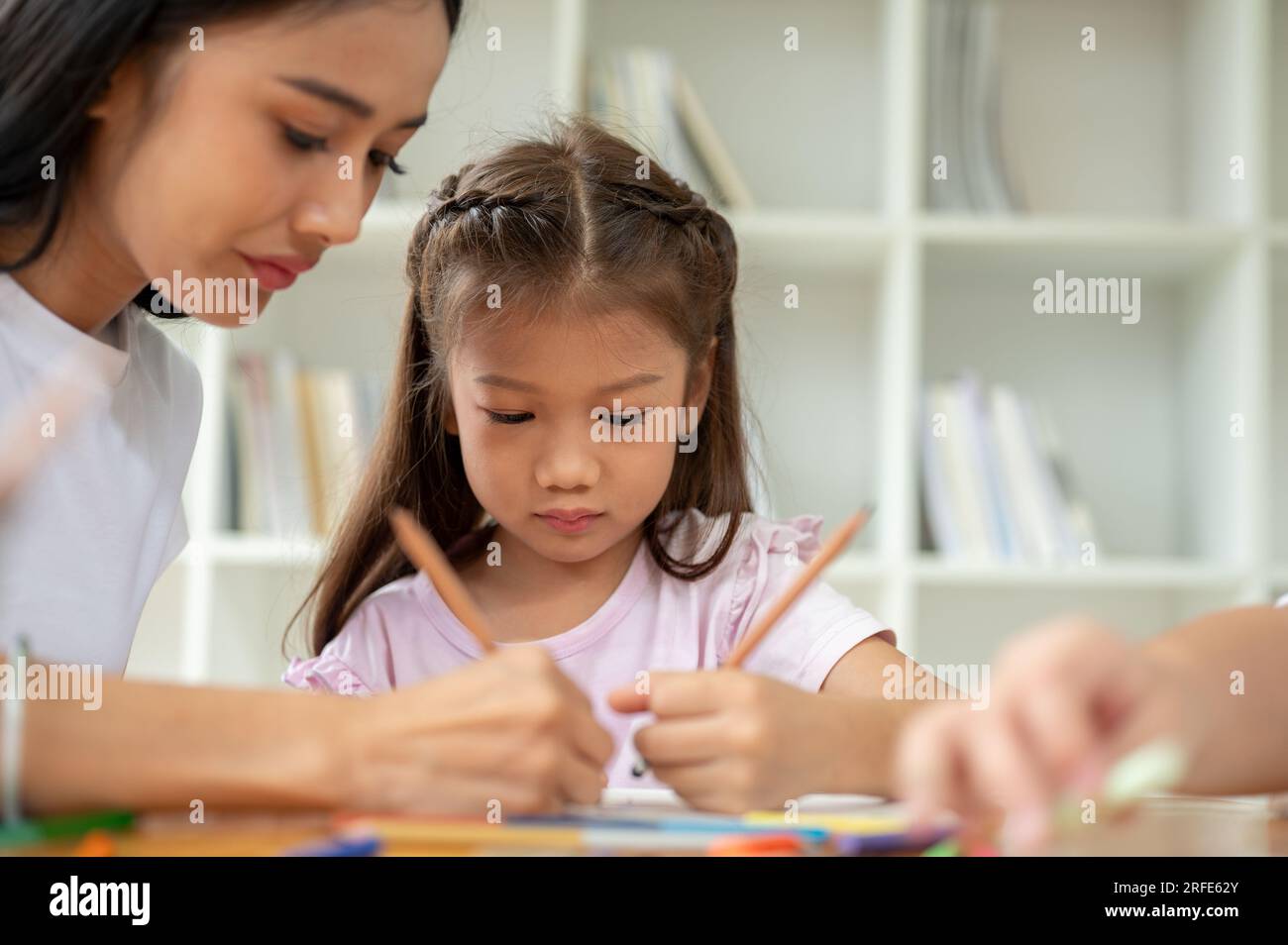 An adorable Asian elementary school girl is focusing on studying ...