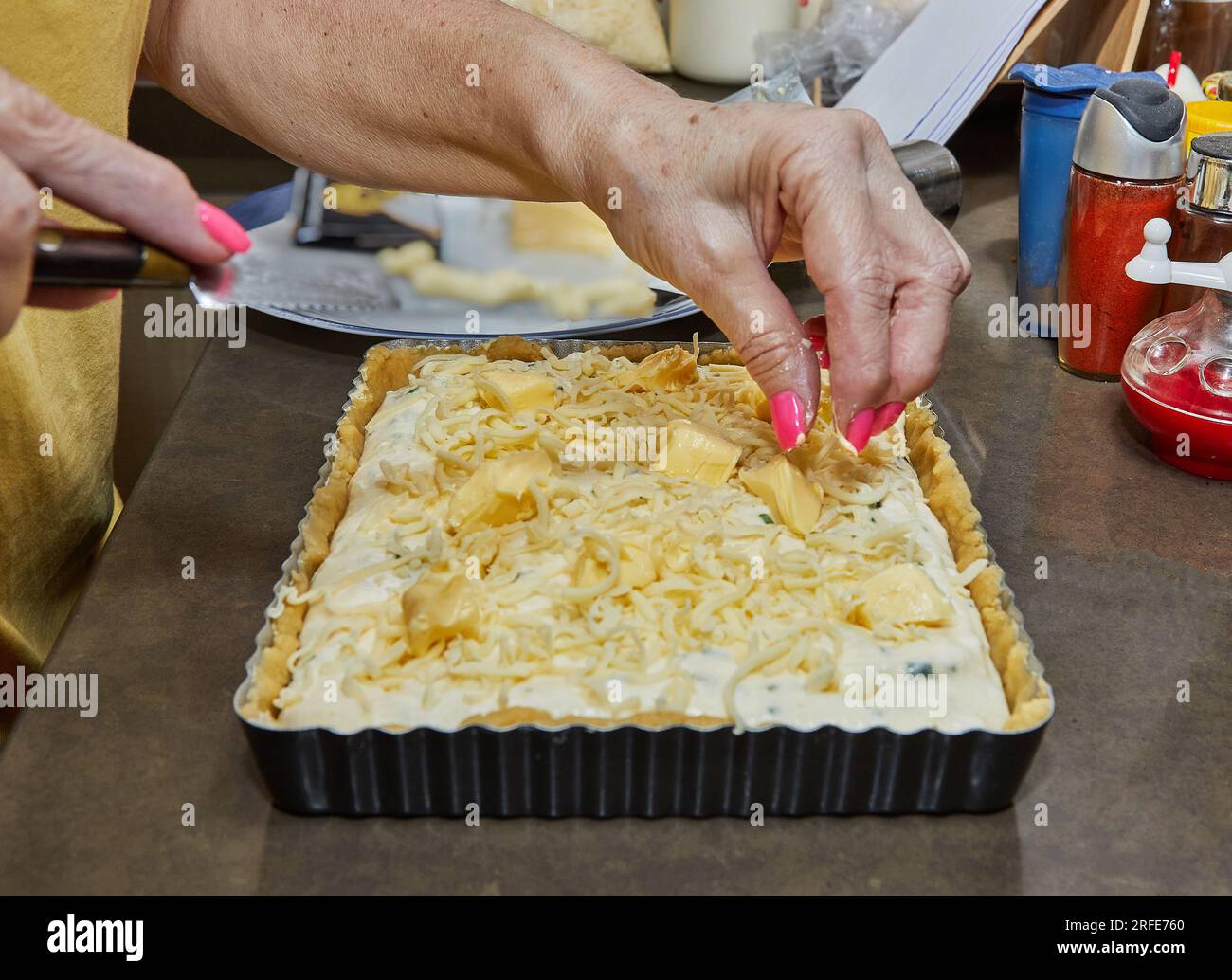 Chef adds butter to square-shaped cheese pie Stock Photo - Alamy