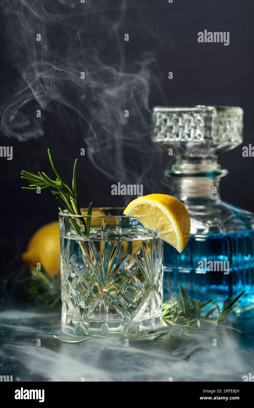 Cocktail Gin-tonic with lemon and rosemary in a crystal glass. Smoked ...