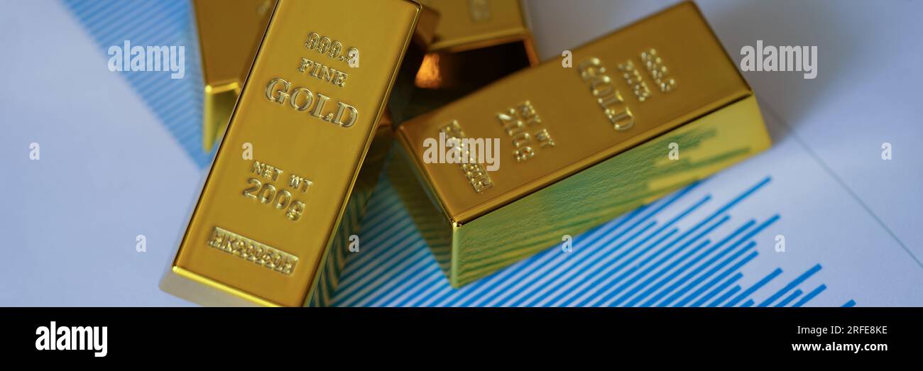 Gold bars on financial documents with charts and graphs close-up Stock ...