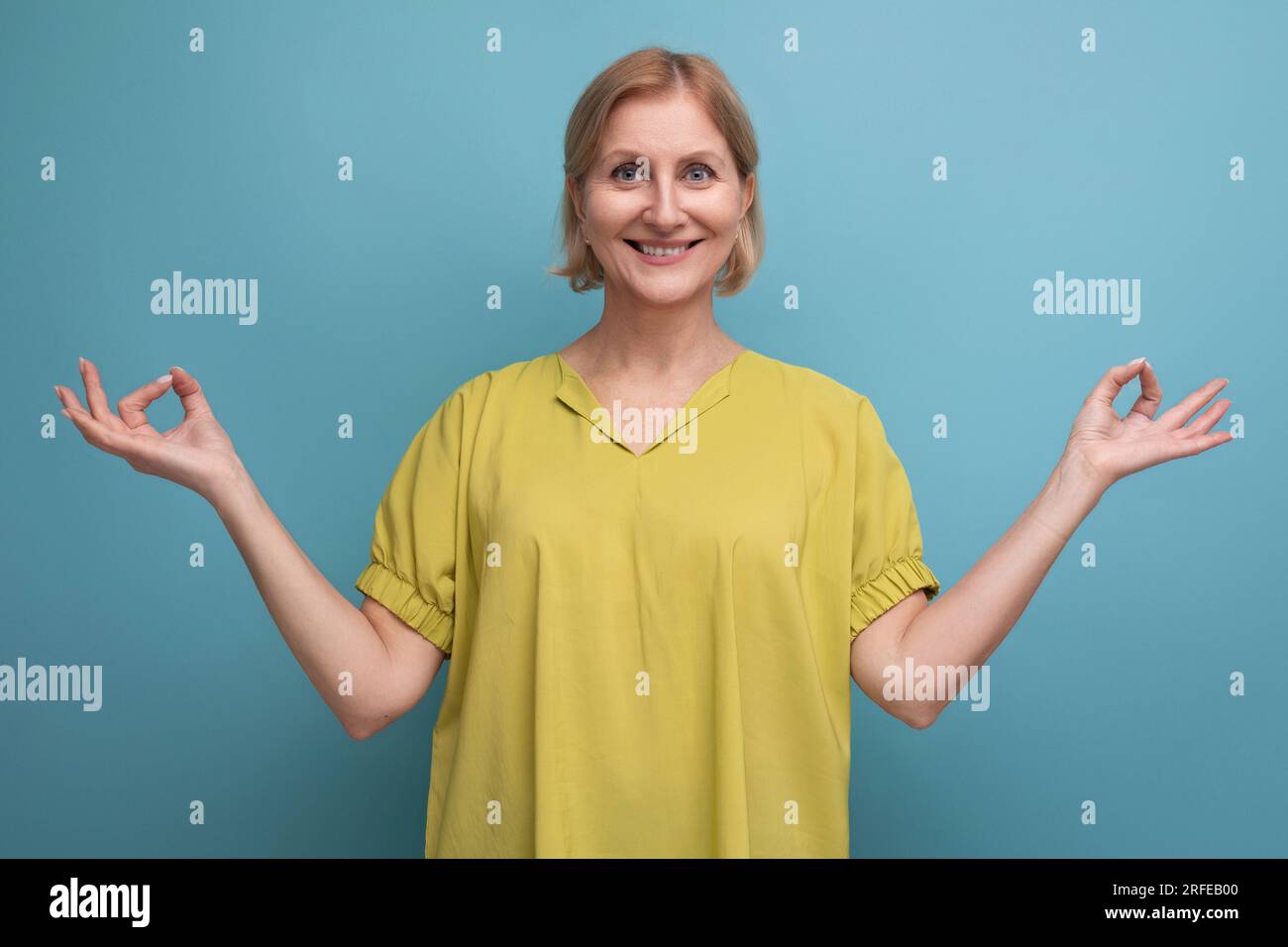 calm middle aged woman with zen feeling spread her arms to the side ...
