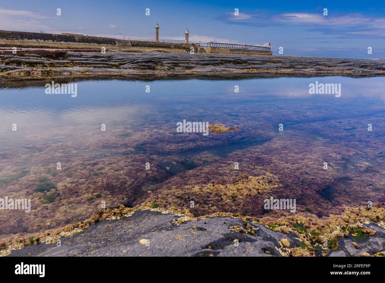 Whitby East Beach at low tide looking over the slate rocks towards the ...