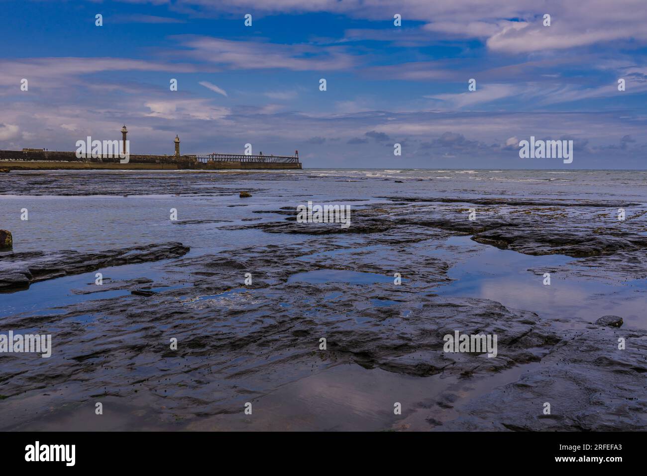 Whitby East Pier at low tide, viewed from the shale rocks in the east ...