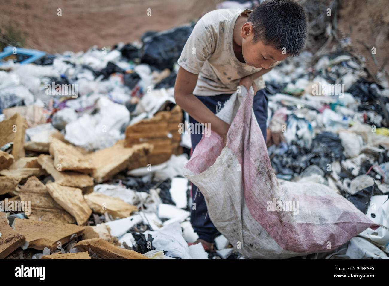 Poor boy collecting garbage in his sack to earn his livelihood, The ...