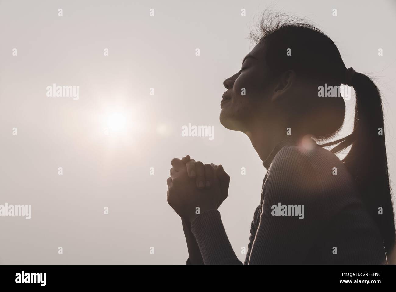 Silhouette of The girl prayed in the mountains to think of a loving God ...