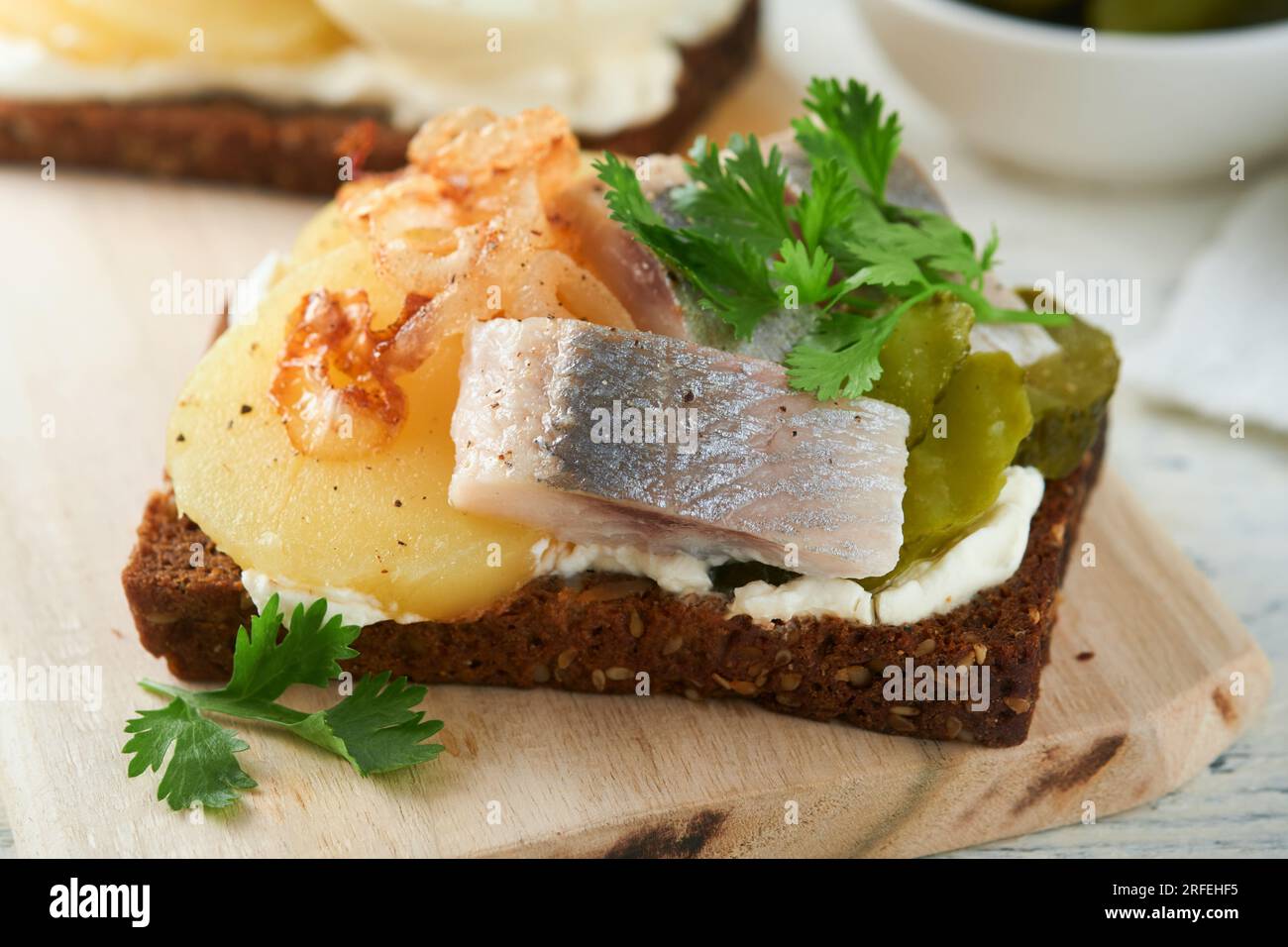 Open sandwich or smorrebrod with rye bread, herring, eggs, caramelized ...