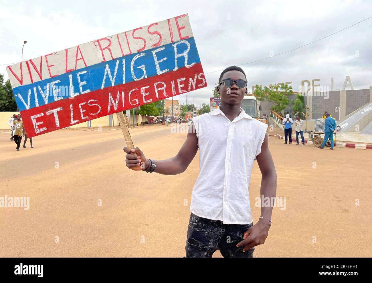 A supporter of Niger's ruling junta holds a placard in the colors of ...