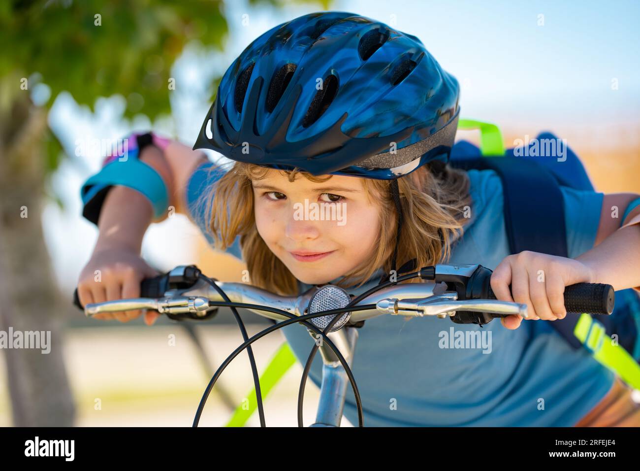 Sporty kid riding bike on a park. Child in safety helmet riding bicycle ...