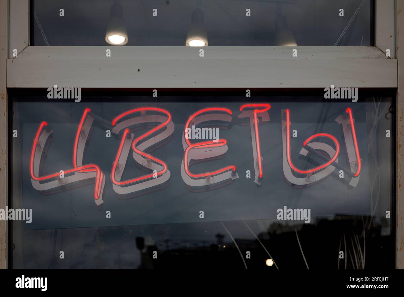 Close-up on red neon light shaped into the russian word "ЦВЕТЫ ...
