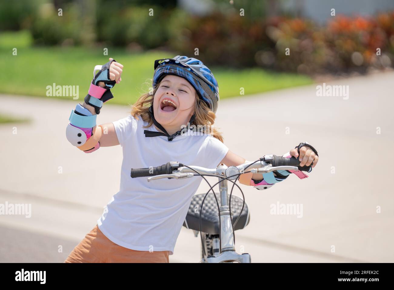 Cute kid riding a bike in summer park. Children learning to drive a ...