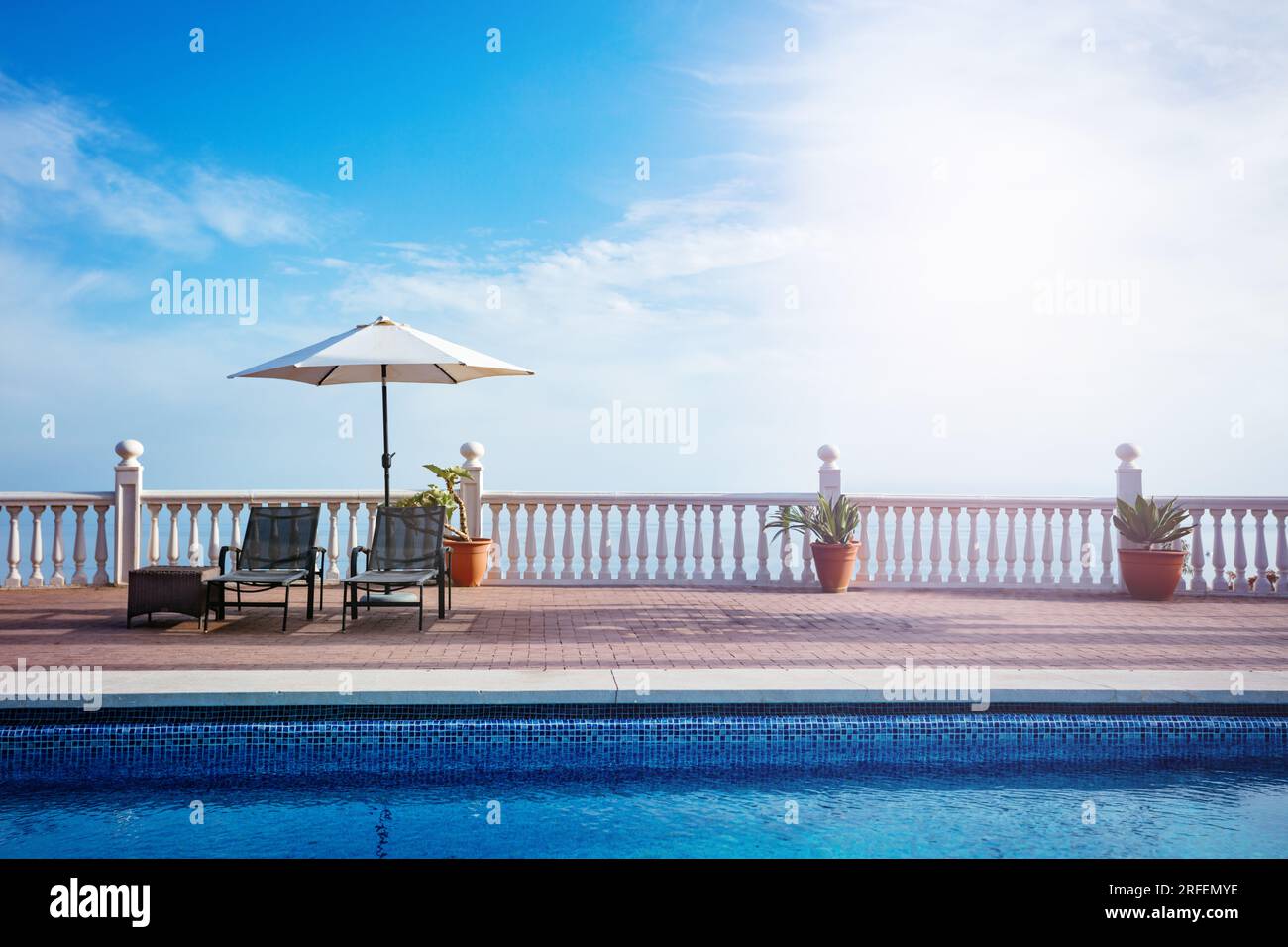 Swimming pool with two desk chairs over clear blue sky Stock Photo - Alamy
