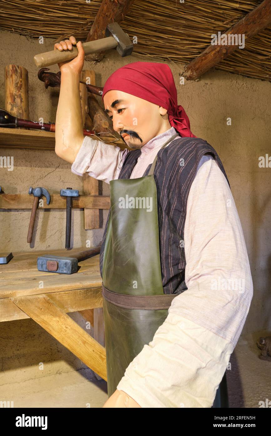 A view of a traditional, old, local Kazakh blacksmith shop with man ...