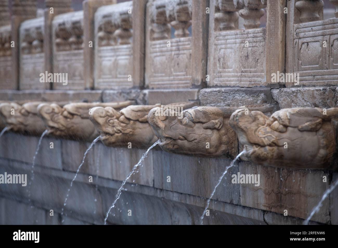 Rainwater spouts from a dragon-shaped ancient drainage system in the ...