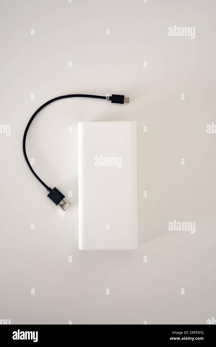 White power bank with black cord cable isolated. White background Stock ...