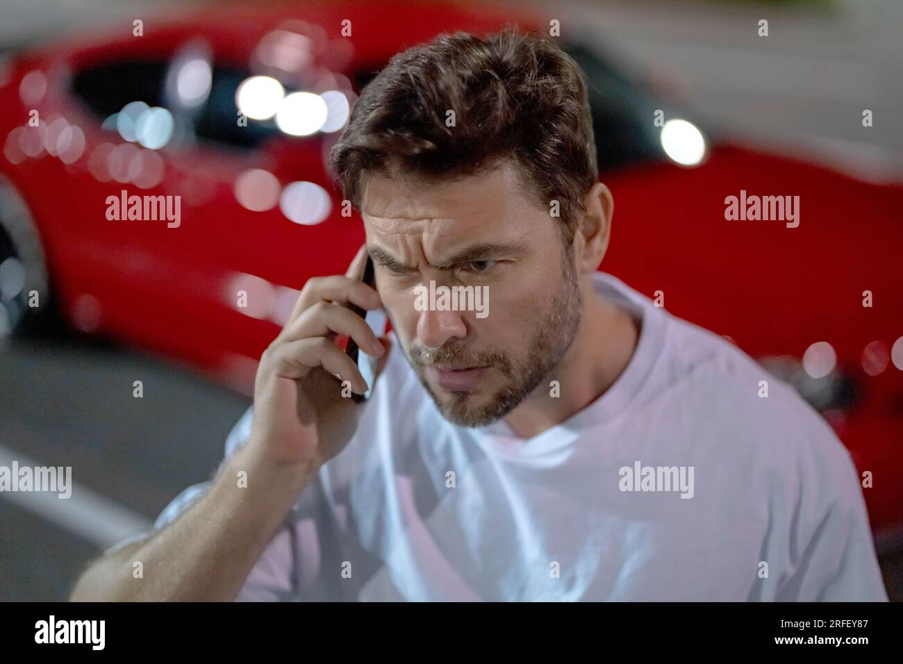 Gangster, criminal concept. Angry man near car on night urban street ...