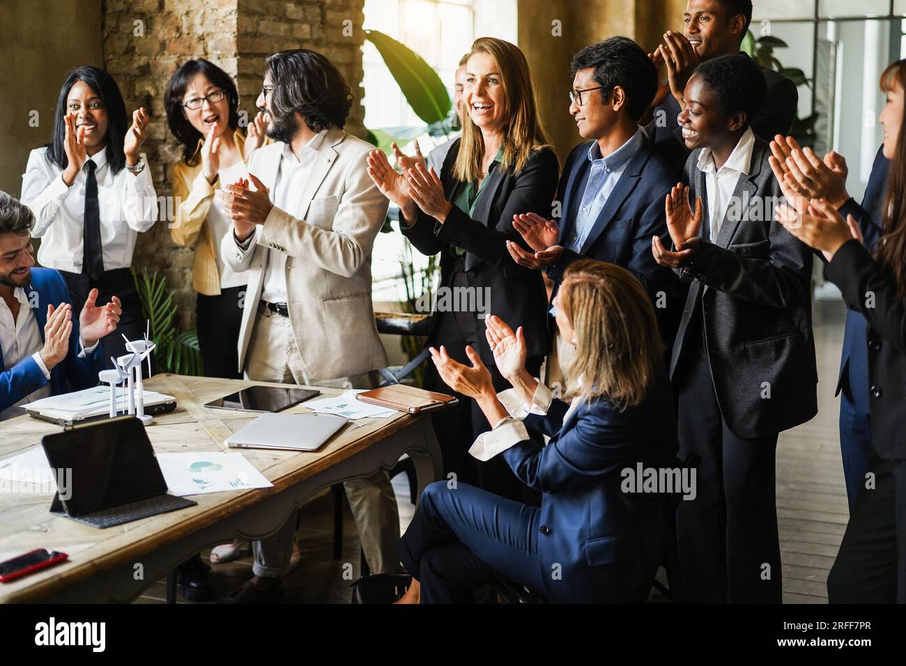 Multigenerational colleagues clapping hands for a succesful green ...