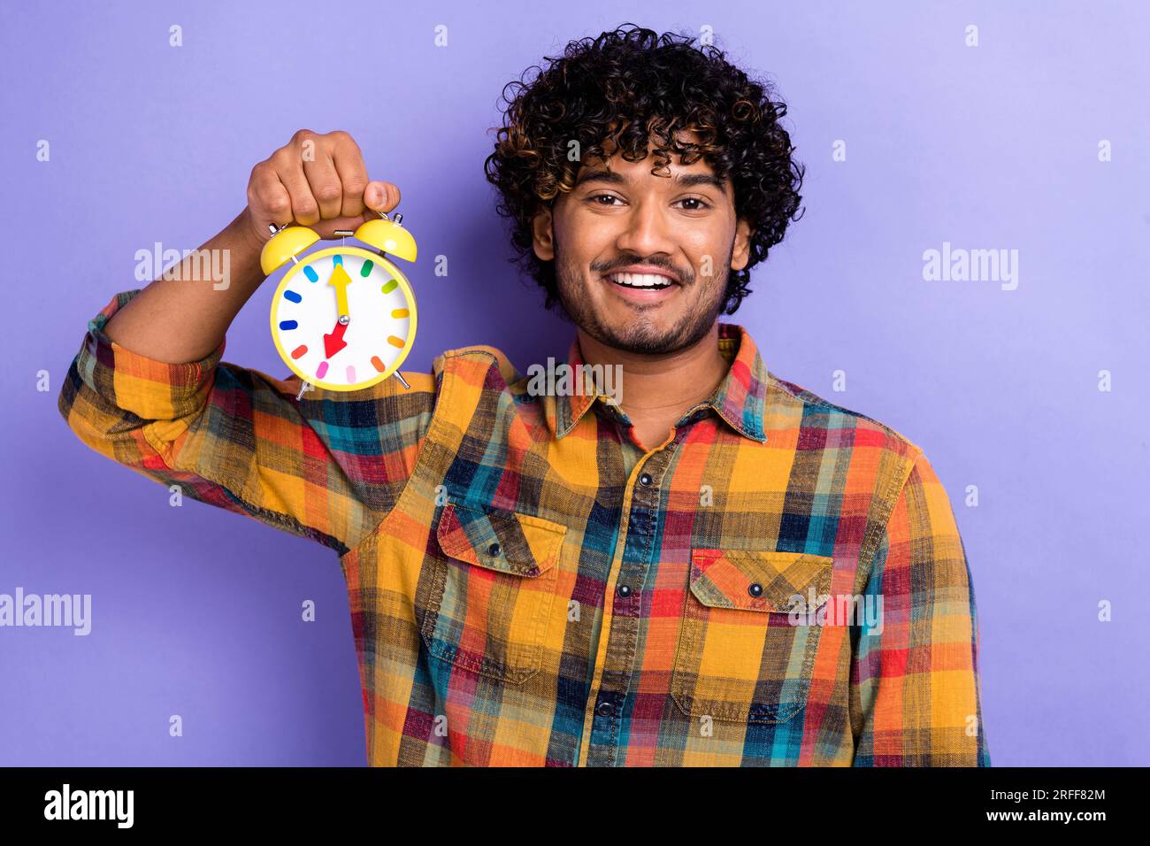 Photo of young man happy smiling showing his alarm oclock timer yellow ...