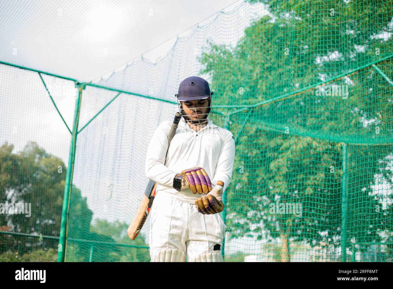 Cricket Player wearing gloves to do practice in cricket nets Stock ...