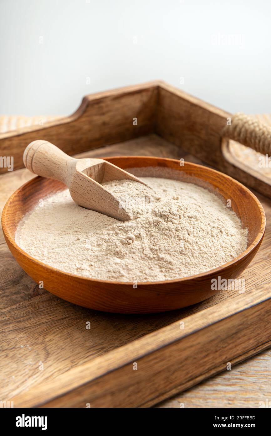 Psyllium husk flour powder on wood bowl and spoon indoors at home ...