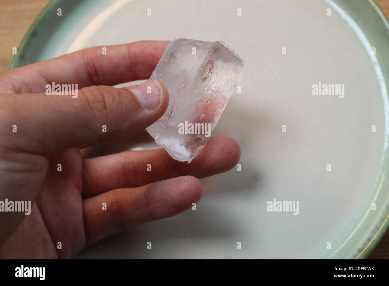 A photo of a person holding an ice cube in their hand Stock Photo - Alamy