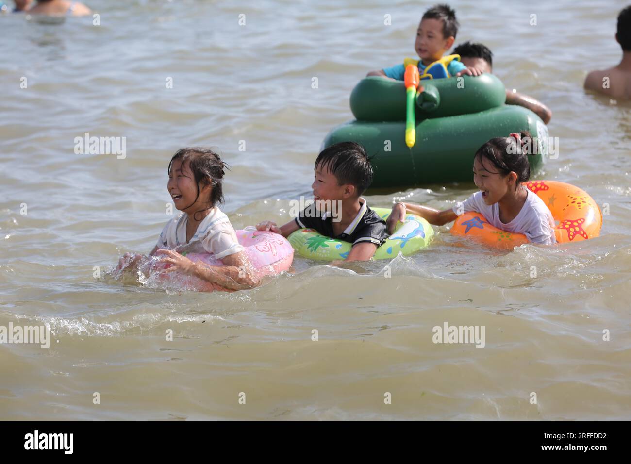 People enjoy summer time at the No 1 bathing beach in Qingdao City ...
