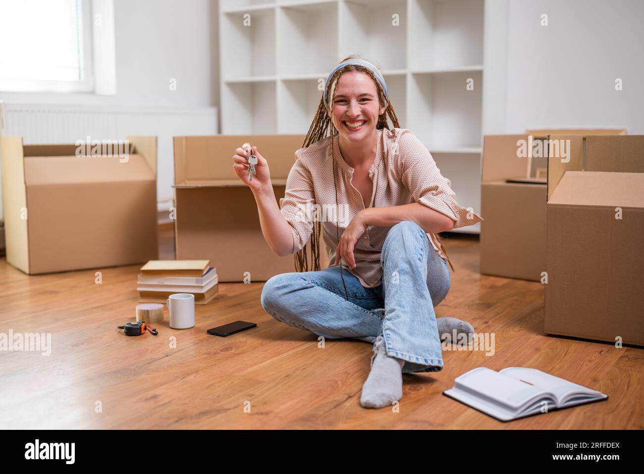Modern ginger woman with braids showing key of her new home Stock Photo ...