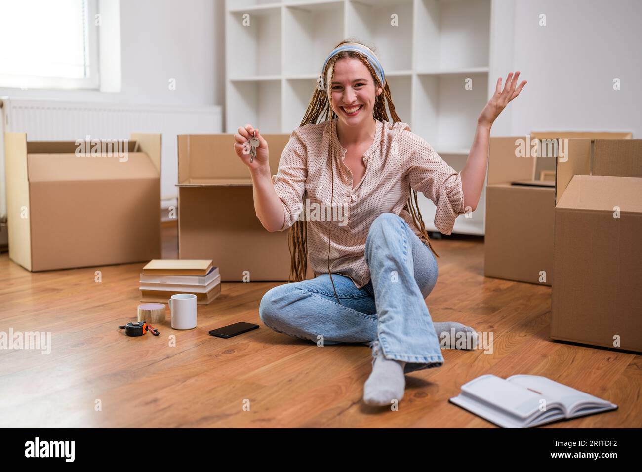 Modern ginger woman with braids showing key of her new home Stock Photo ...