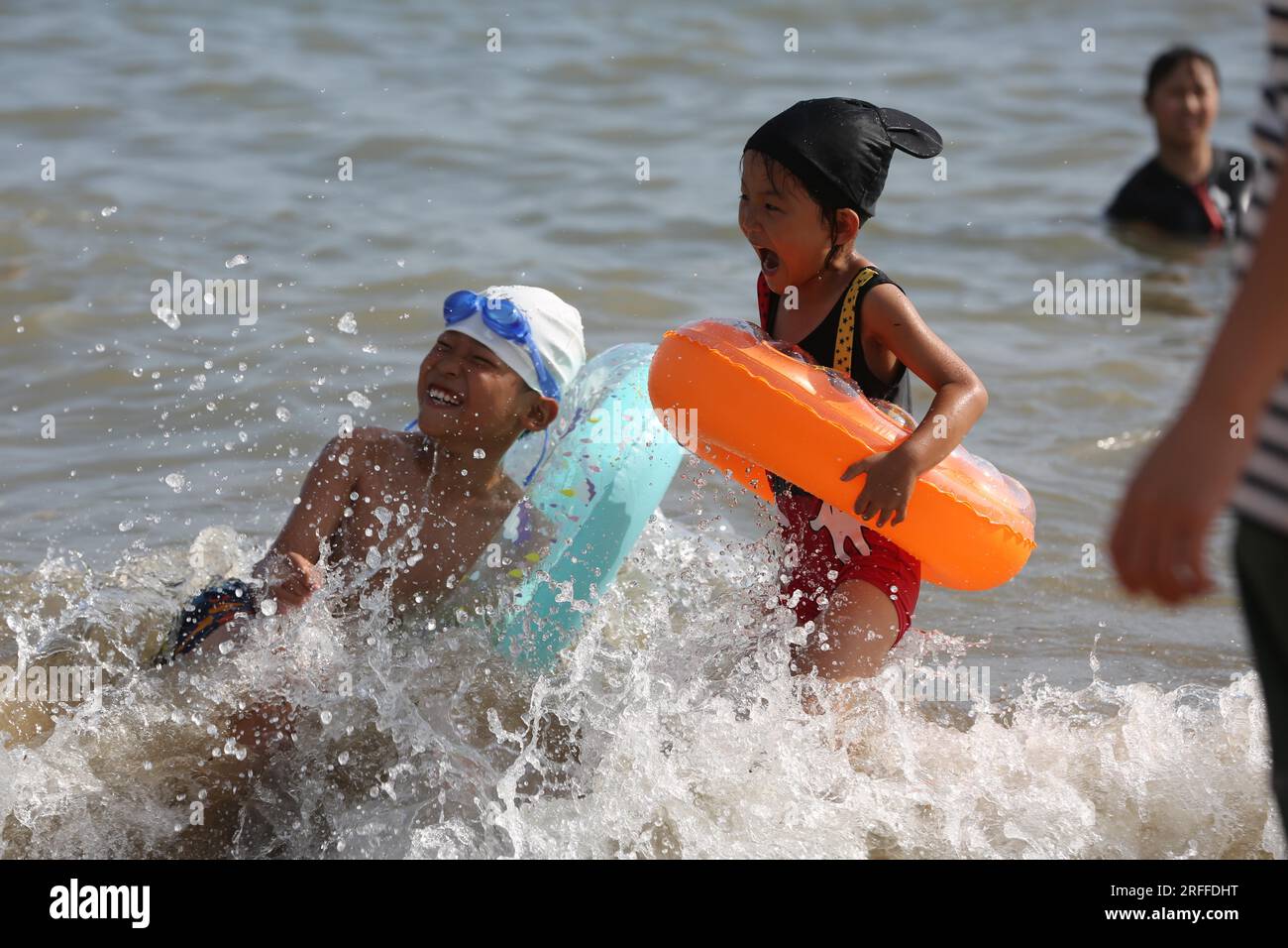 People enjoy summer time at the No 1 bathing beach in Qingdao City ...