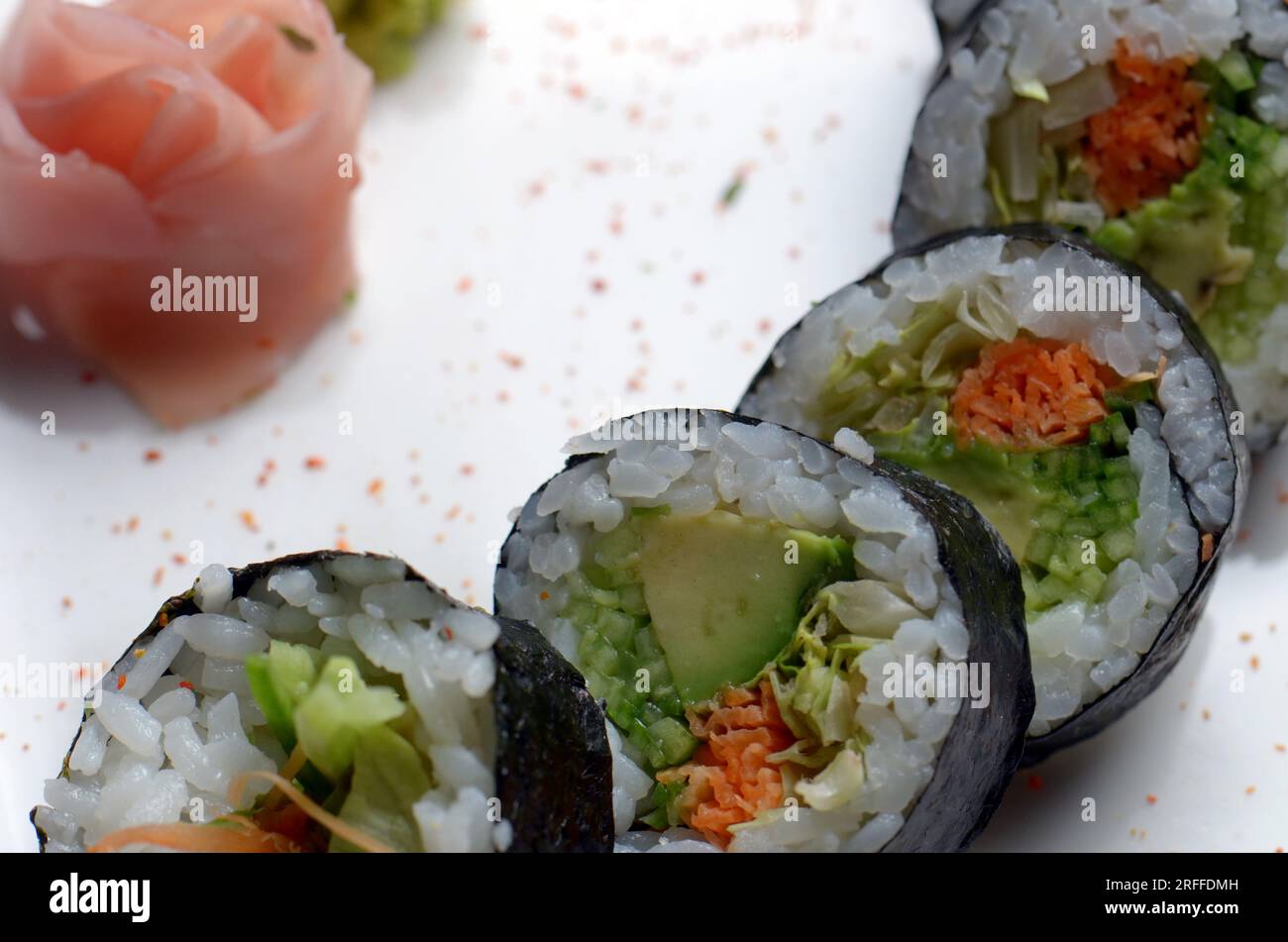 Sushi stuffed with rice and avocado wrapped in sea weed on a white ...