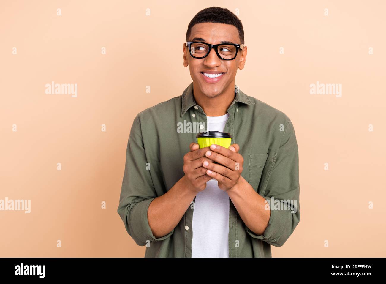 Photo of tricky cunning man wear khaki shirt spectacles drinking tea ...