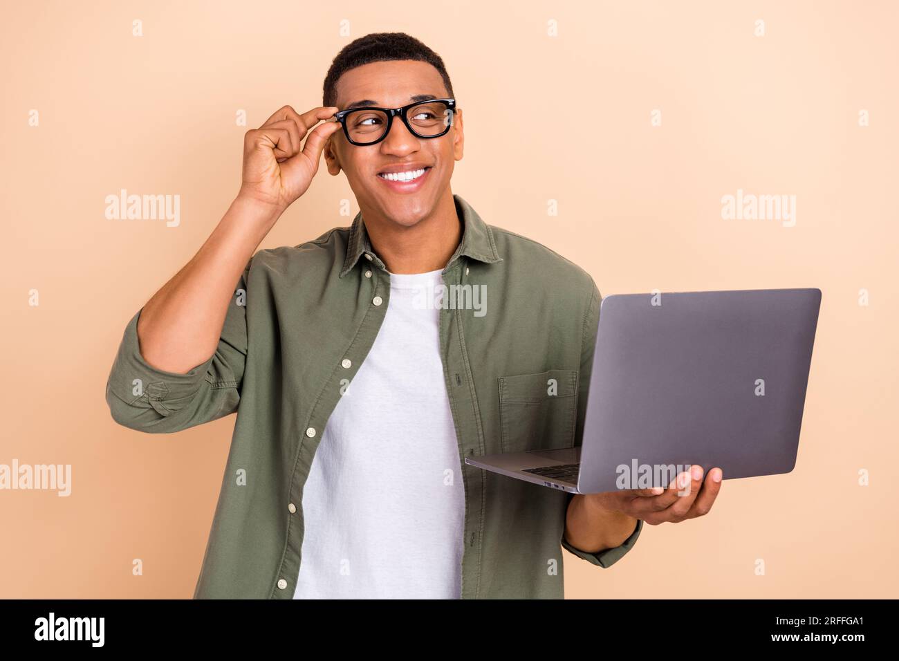 Portrait of minded handsome guy arm touch glasses hold netbook look ...