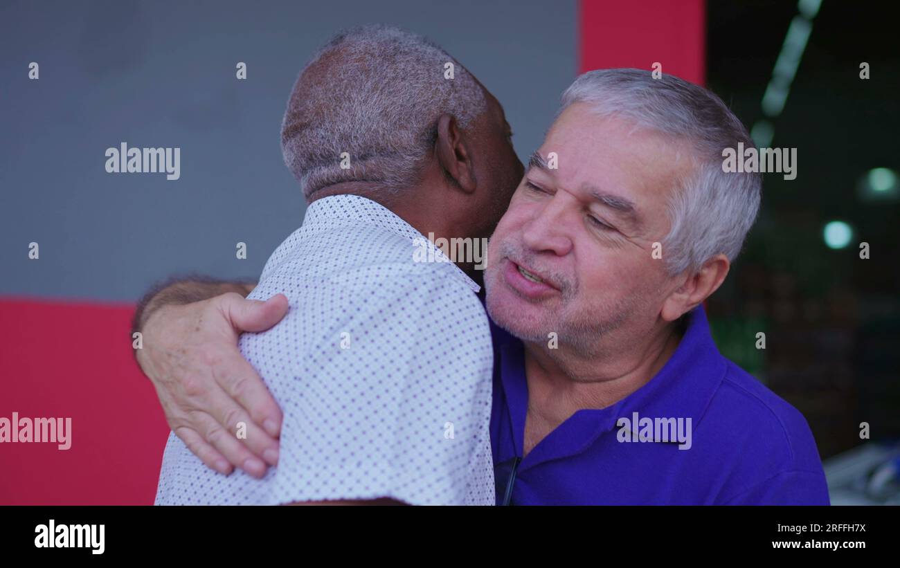 Two senior diverse friends embrace in street, candid camaraderie scene ...