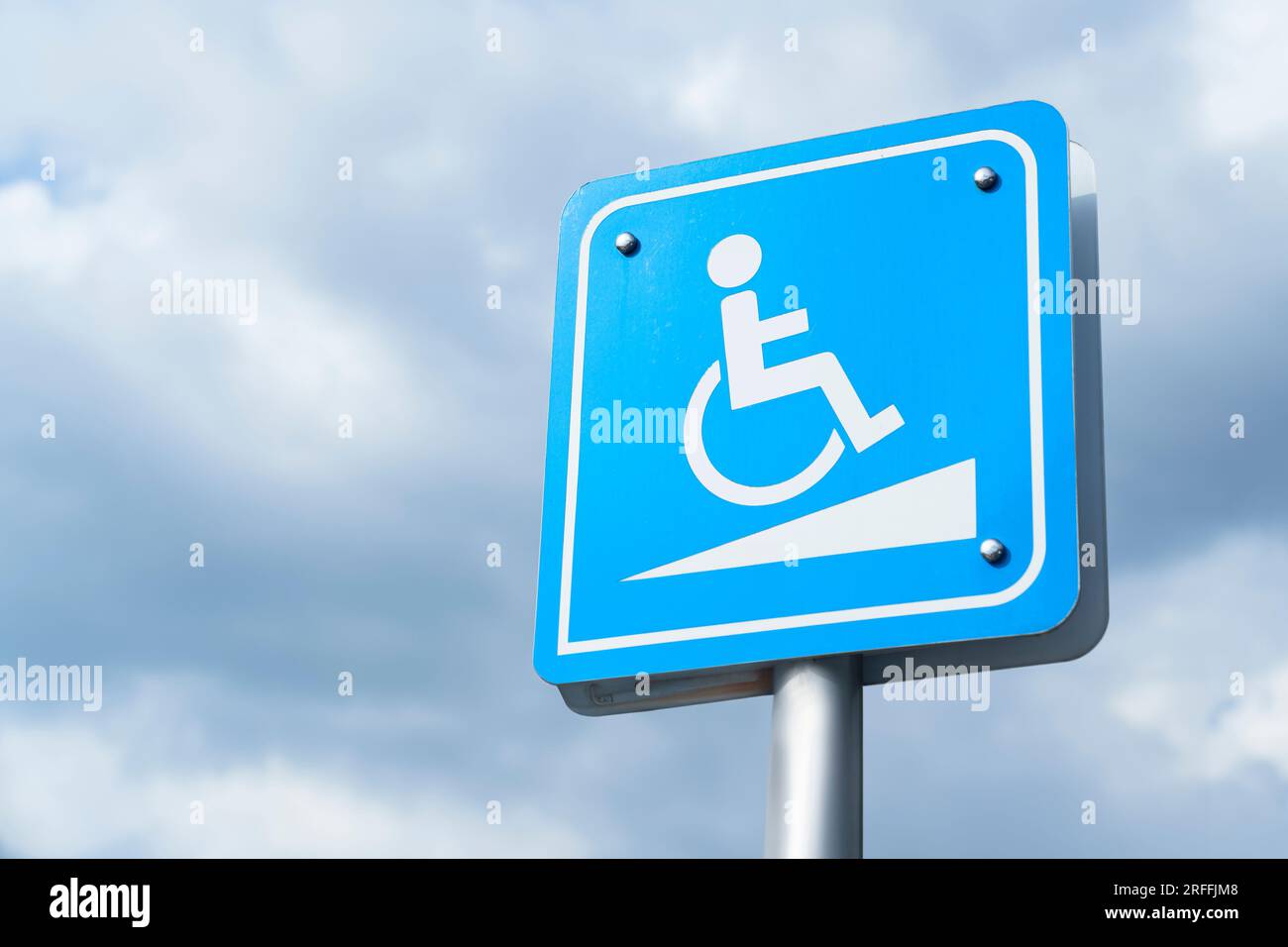 Wheelchair ramp sign against blue sky, copyspace Stock Photo - Alamy