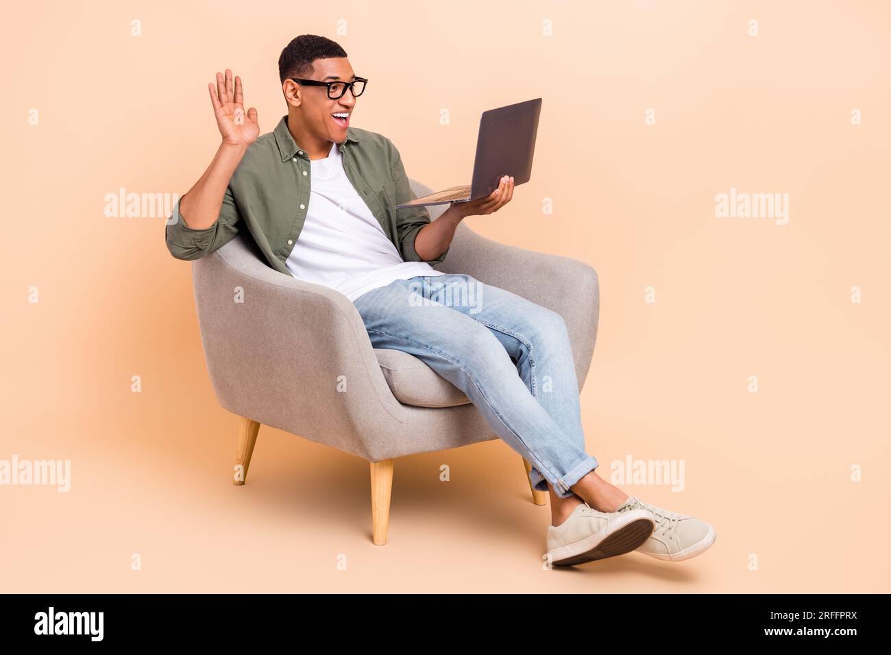Full length portrait of positive man sit chair arm palm waving hi video ...