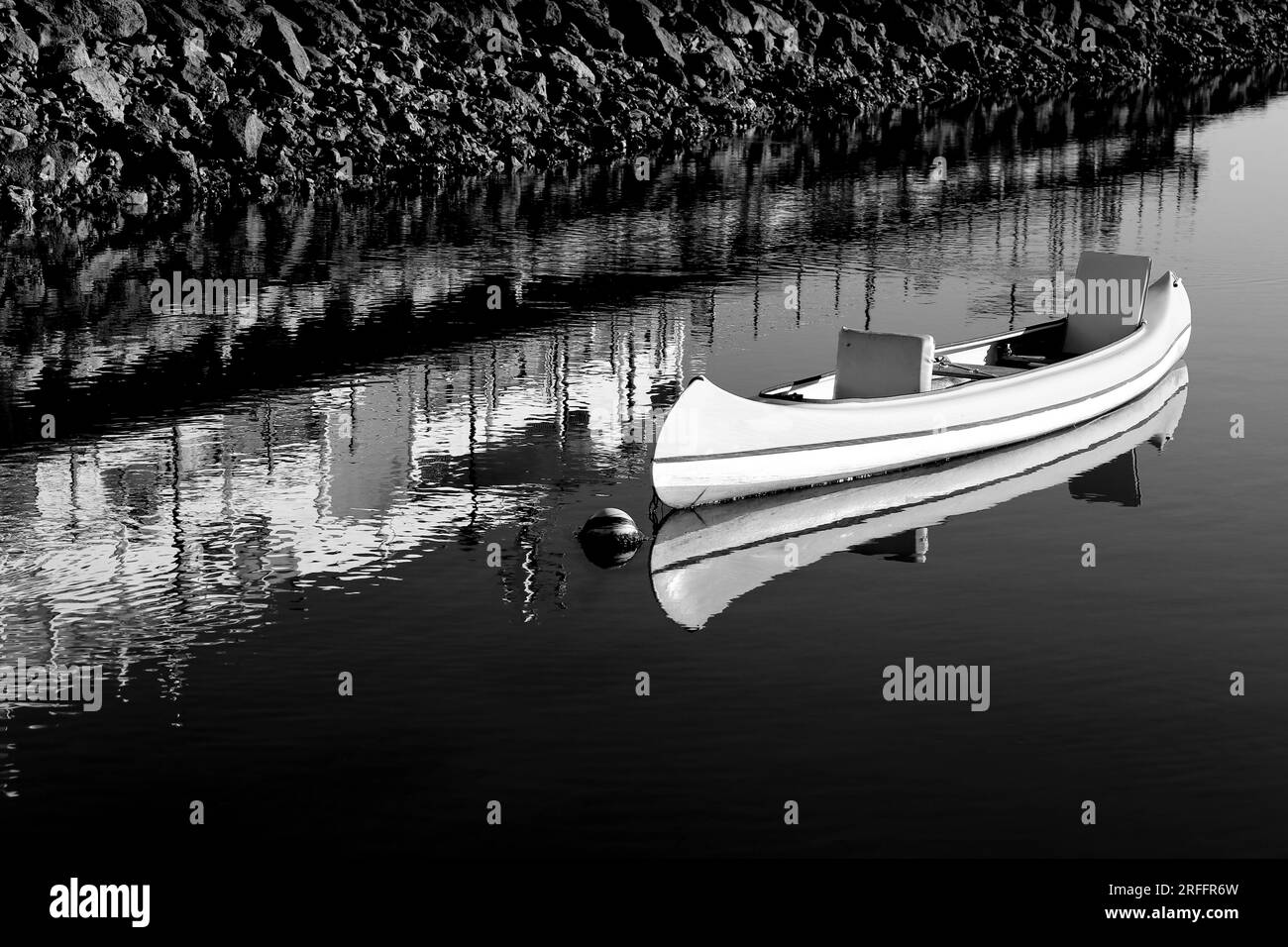 Beautiful canoe anchored on calm water in Tavira, Portugal Stock Photo ...
