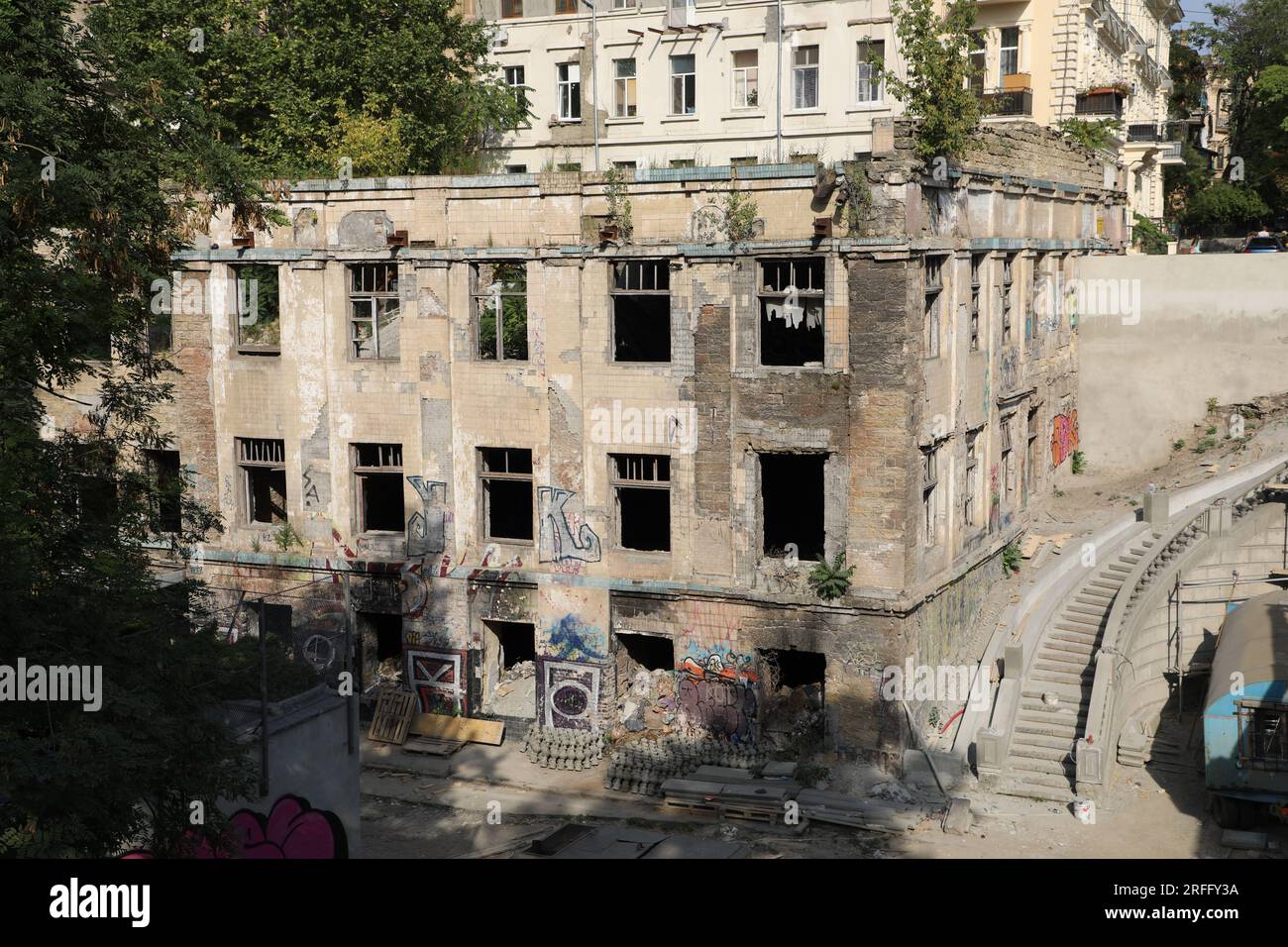 Facade of an old dilapidated building with broken windows; new stone ...