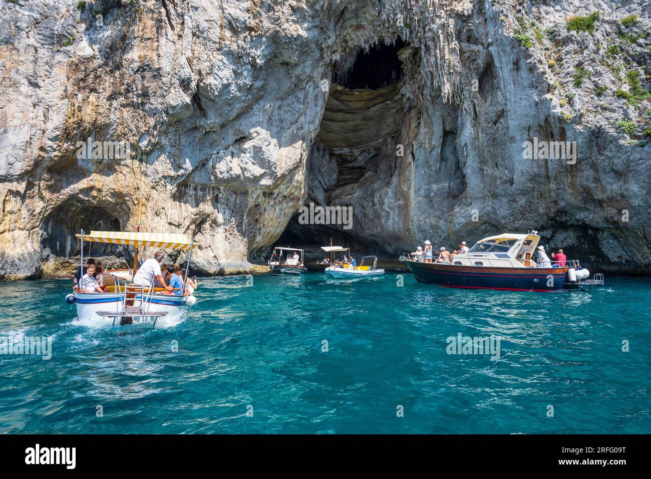 Tourist boats jockey for position at the entrance to Grotto Bianca, a ...