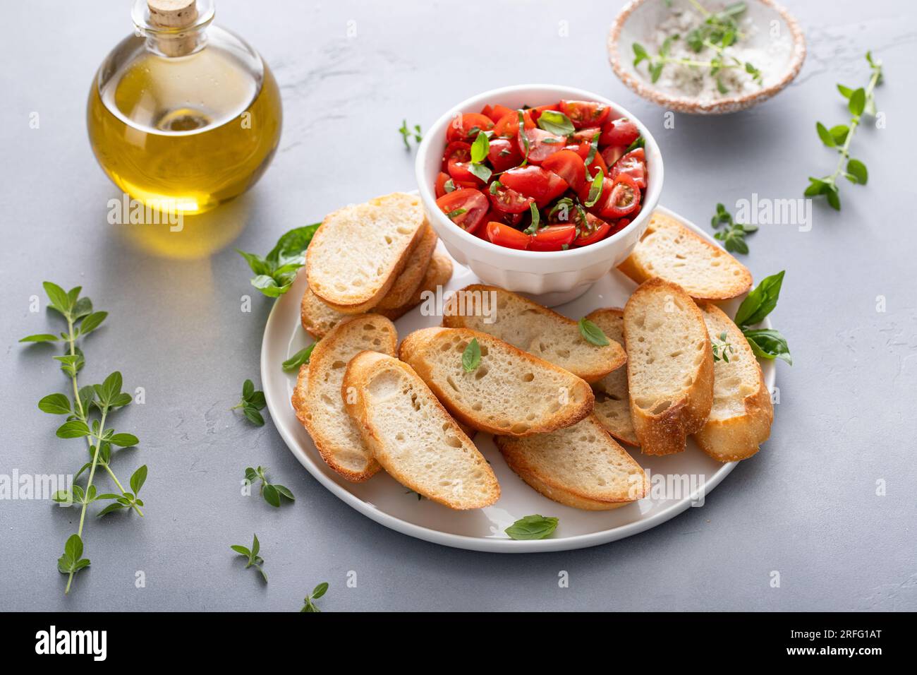 Making tomato basil bruschetta with toasted baguette and fresh herbs ...