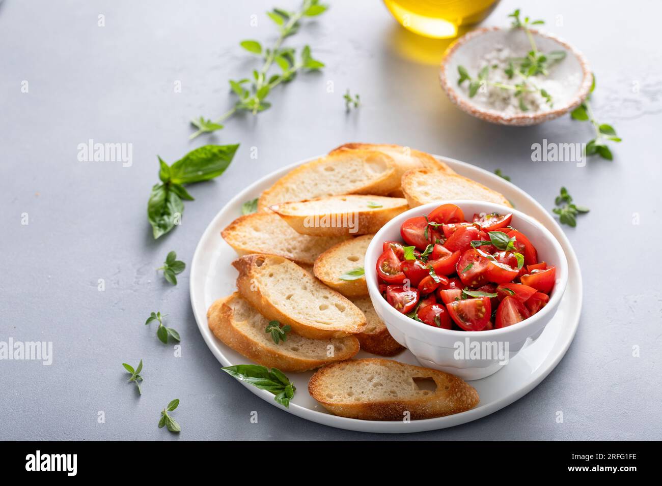 Making tomato basil bruschetta with toasted baguette and fresh herbs ...