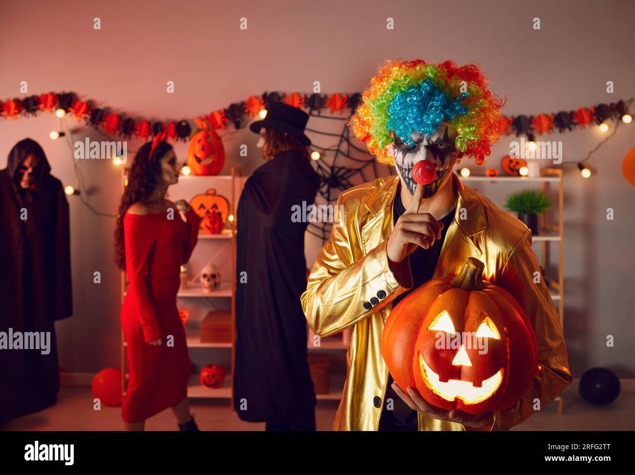 Man dressed as evil clown doing silencing finger on lip gesture at ...