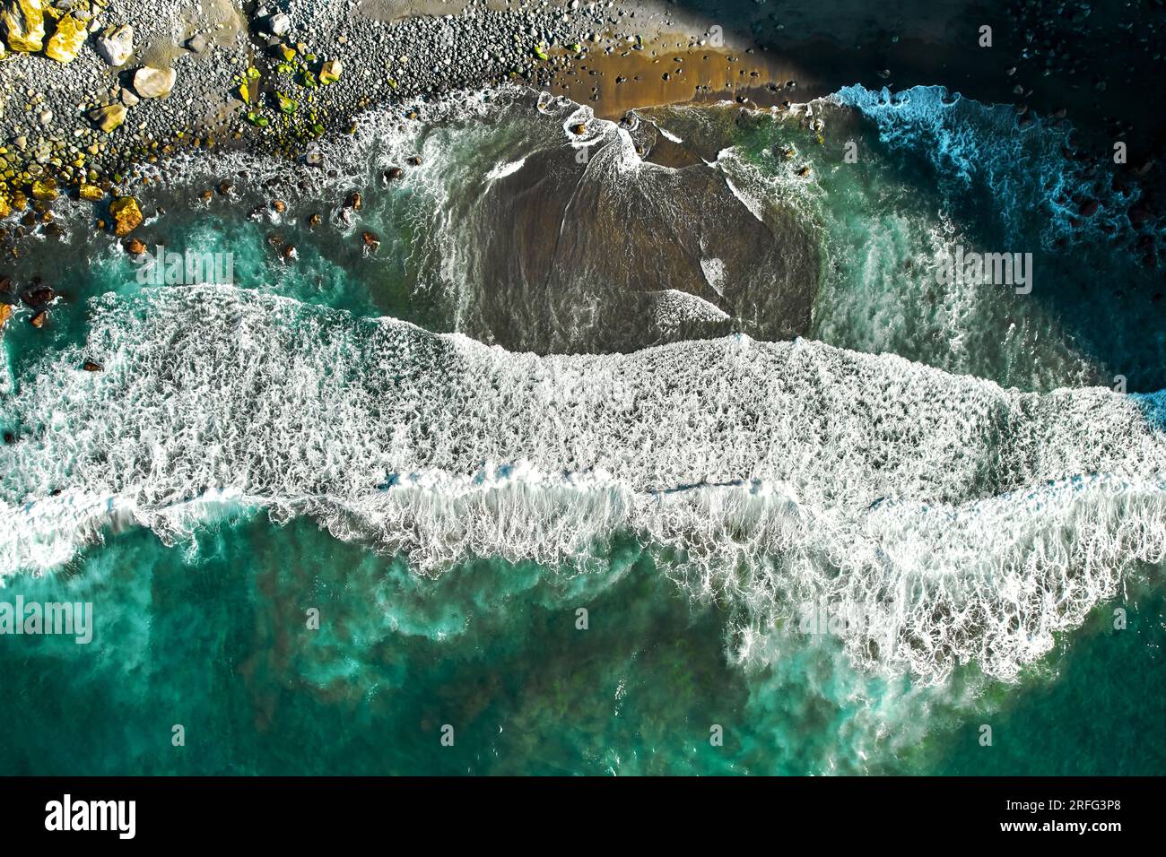 Aerial shot stony volcanic beach, drone point of view breaking waves of ...