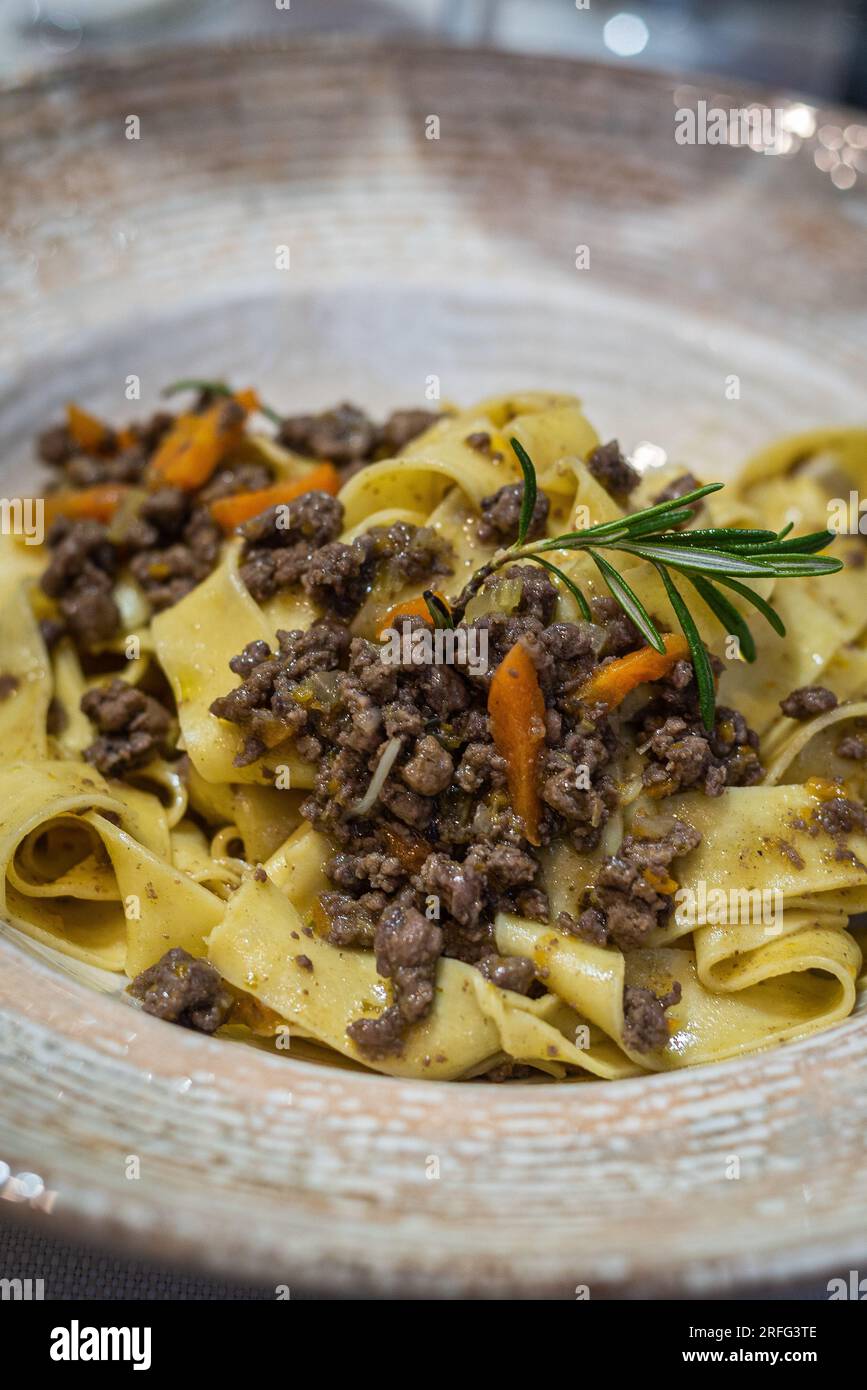 Wild Boar Ragu on wide egg pasta in a bowl ready to eat Stock Photo - Alamy