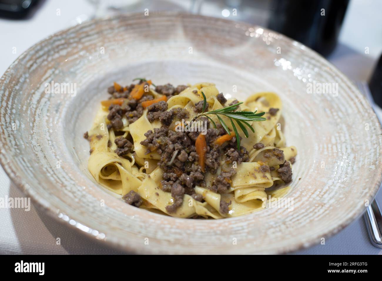 Wild Boar Ragu on wide egg pasta in a bowl ready to eat Stock Photo - Alamy
