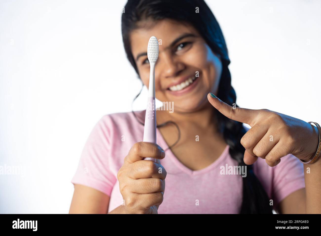 An Indian woman female girl showing tooth brush on white background ...