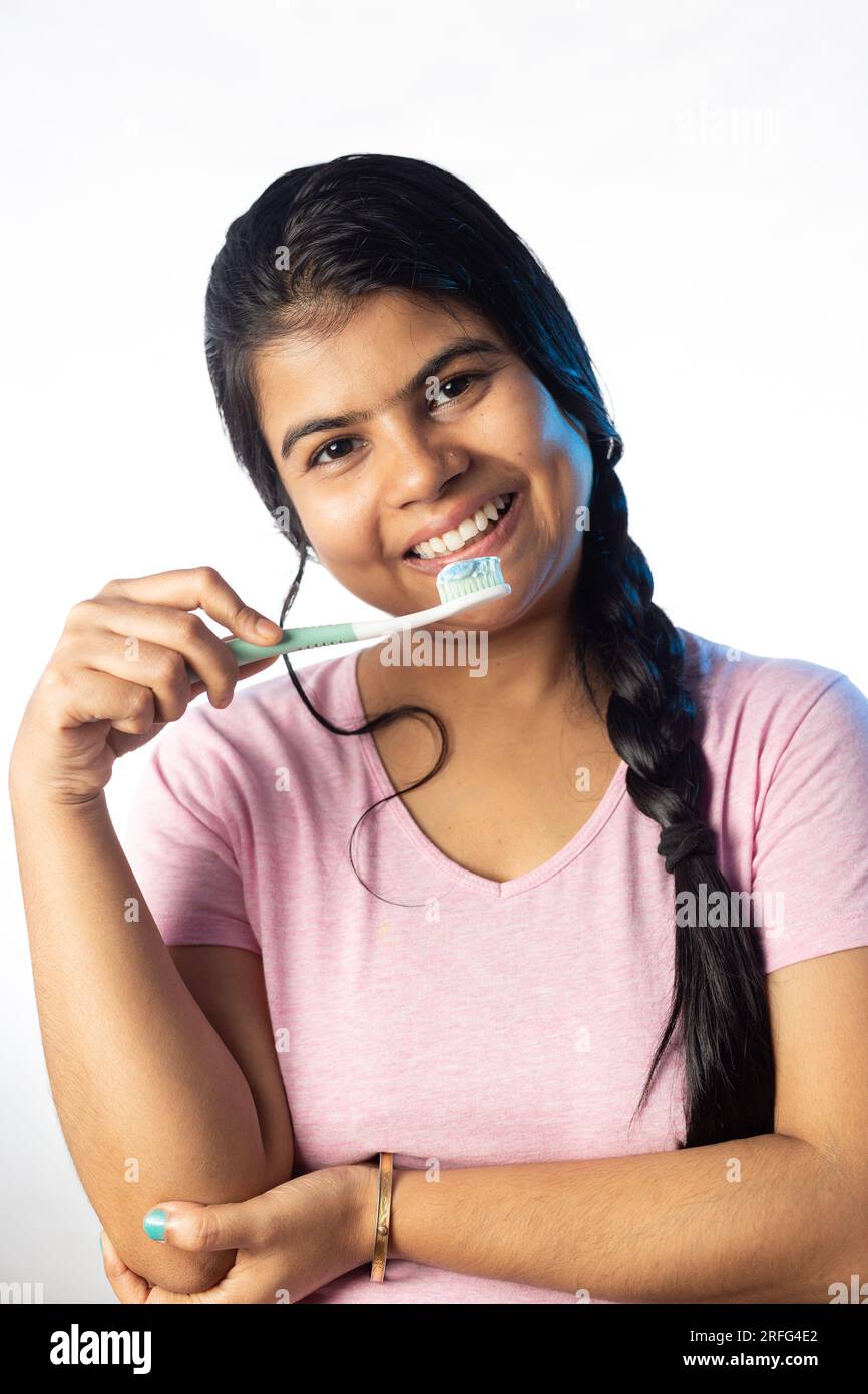 An Indian woman female girl brushing teeth on white background with ...