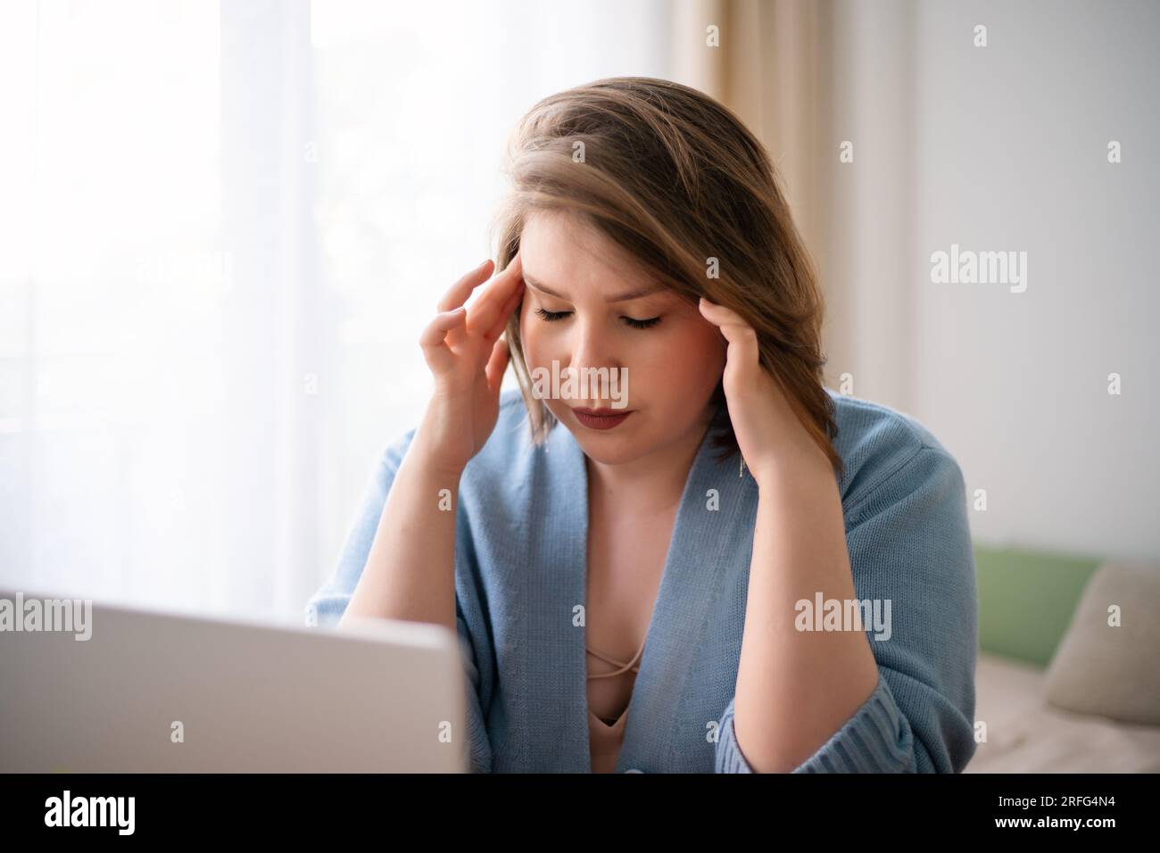 Plus size young woman massaging temples by fingers, headache and health ...