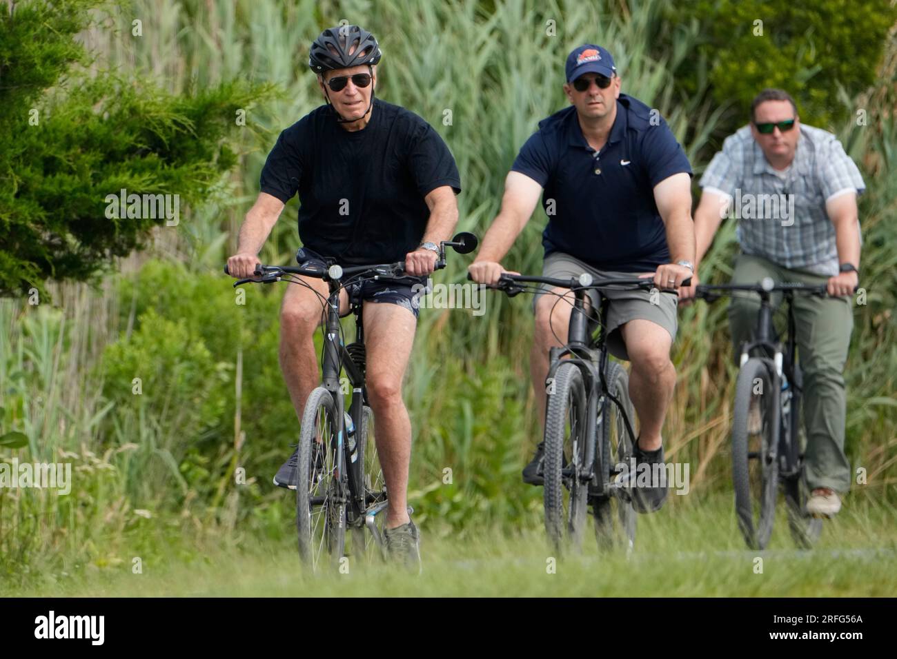 President Joe Biden rides his bike on a bike path at Gordons Pond in ...