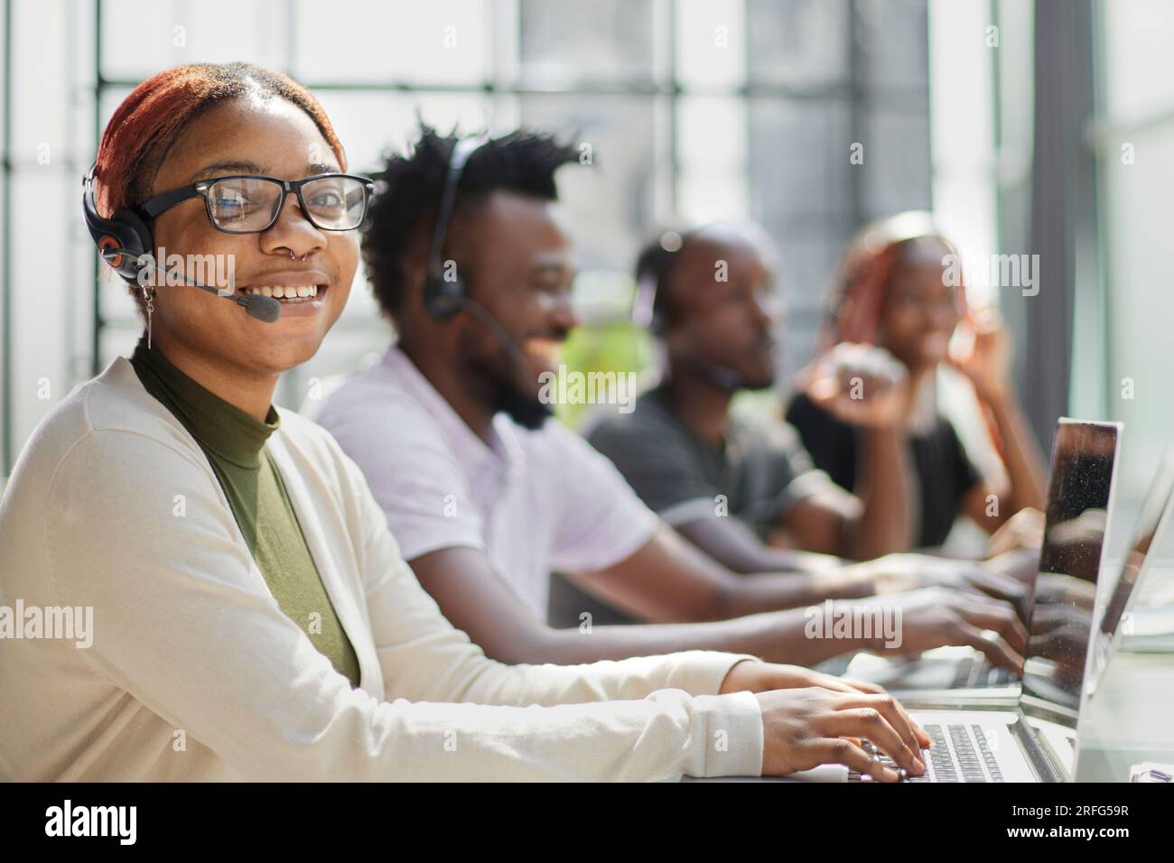 call center agents smiling happy working at the office Stock Photo - Alamy